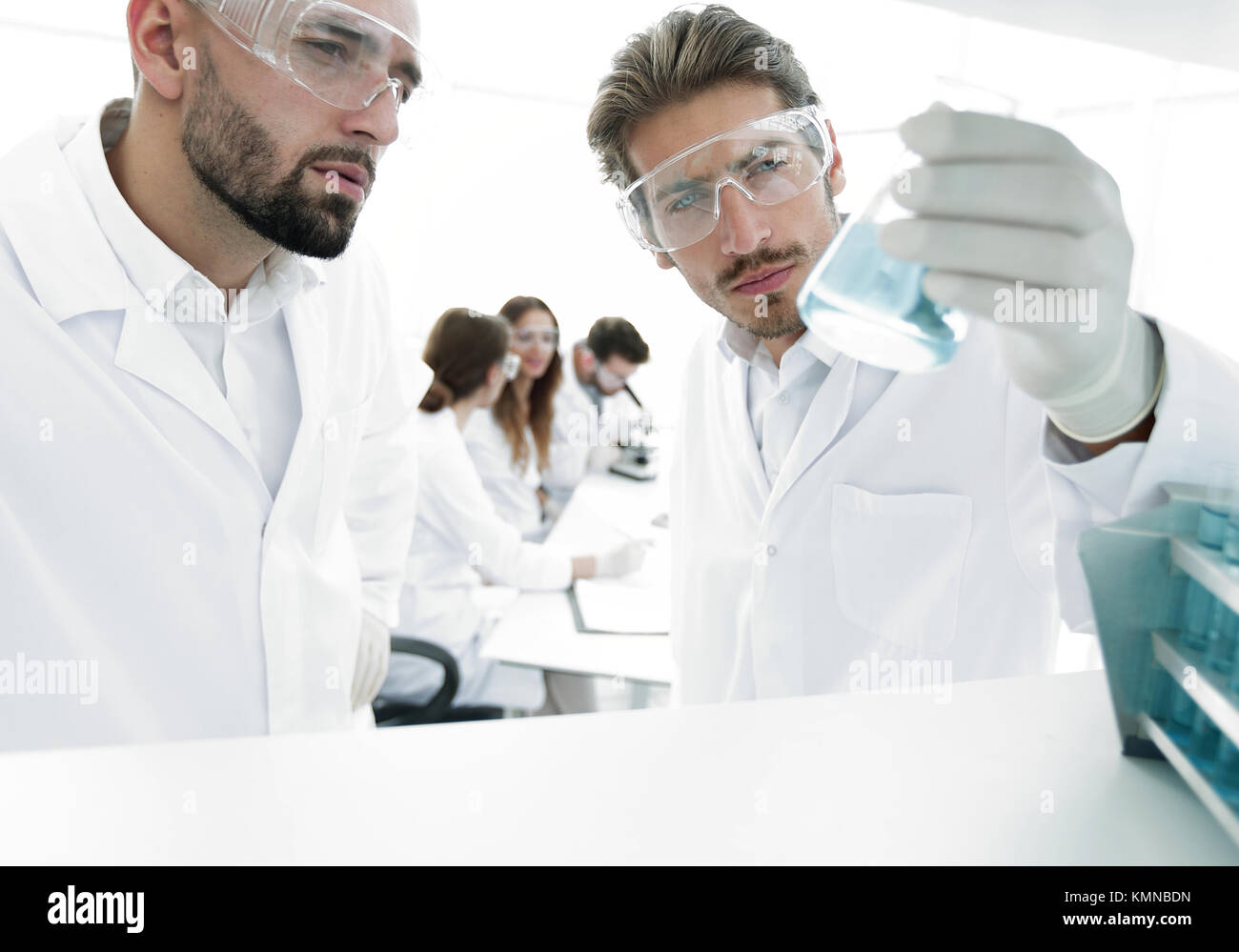 closeup. scientist and assistant studying the solution in the glass ...