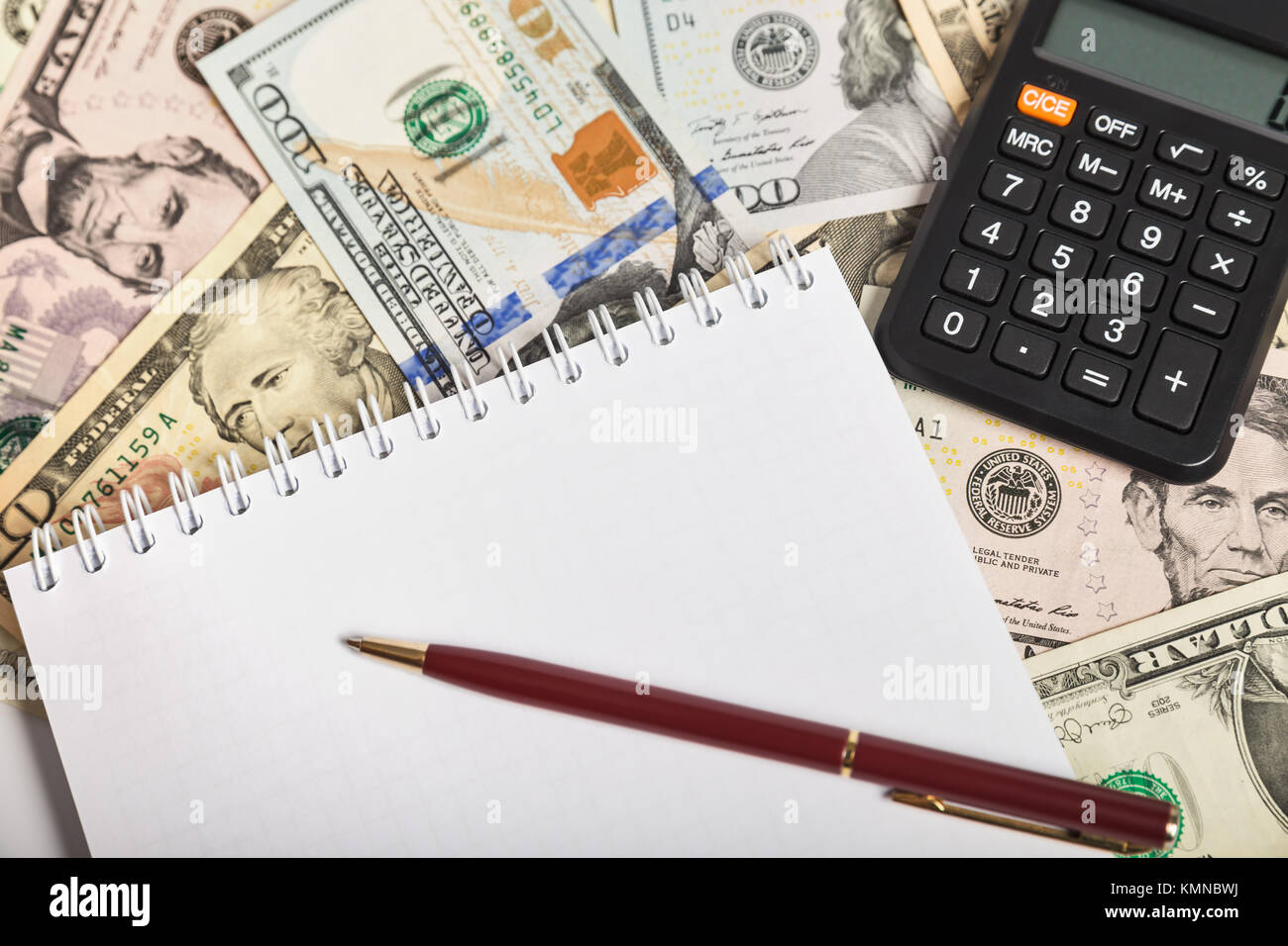 Notepad with blank sheet, pen and calculator on a background of ...