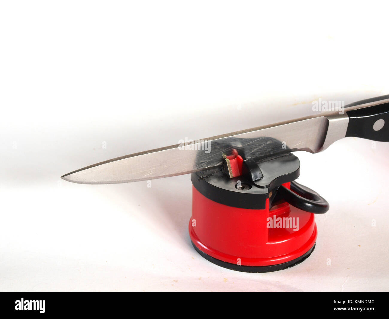 Knife sharpening on special sharpener close up on white background ...