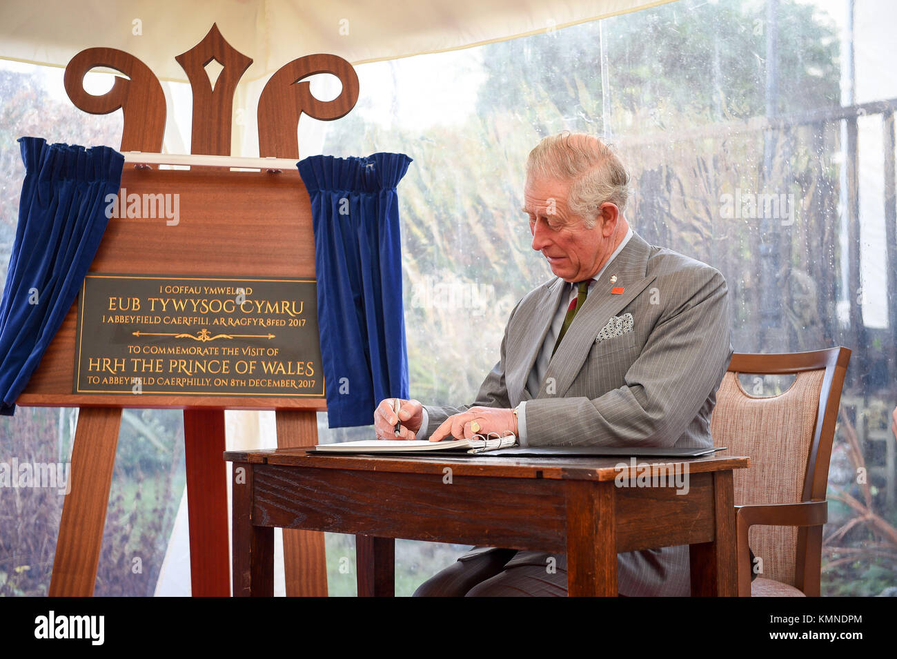 The Prince of Wales signs the visitors book during his visit to the ...