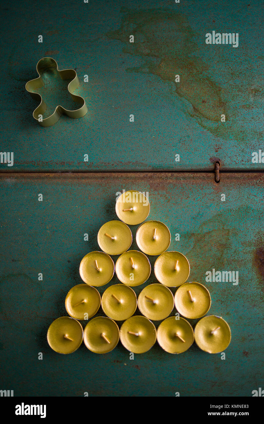 Golden candles form the shape of a christmas tree with a cookies cutlet ...