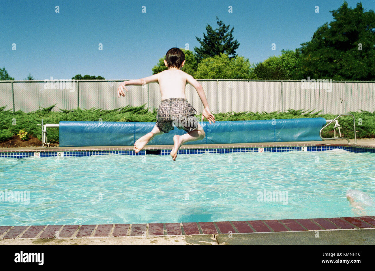 6 year old boy jumping into pool Stock Photo - Alamy