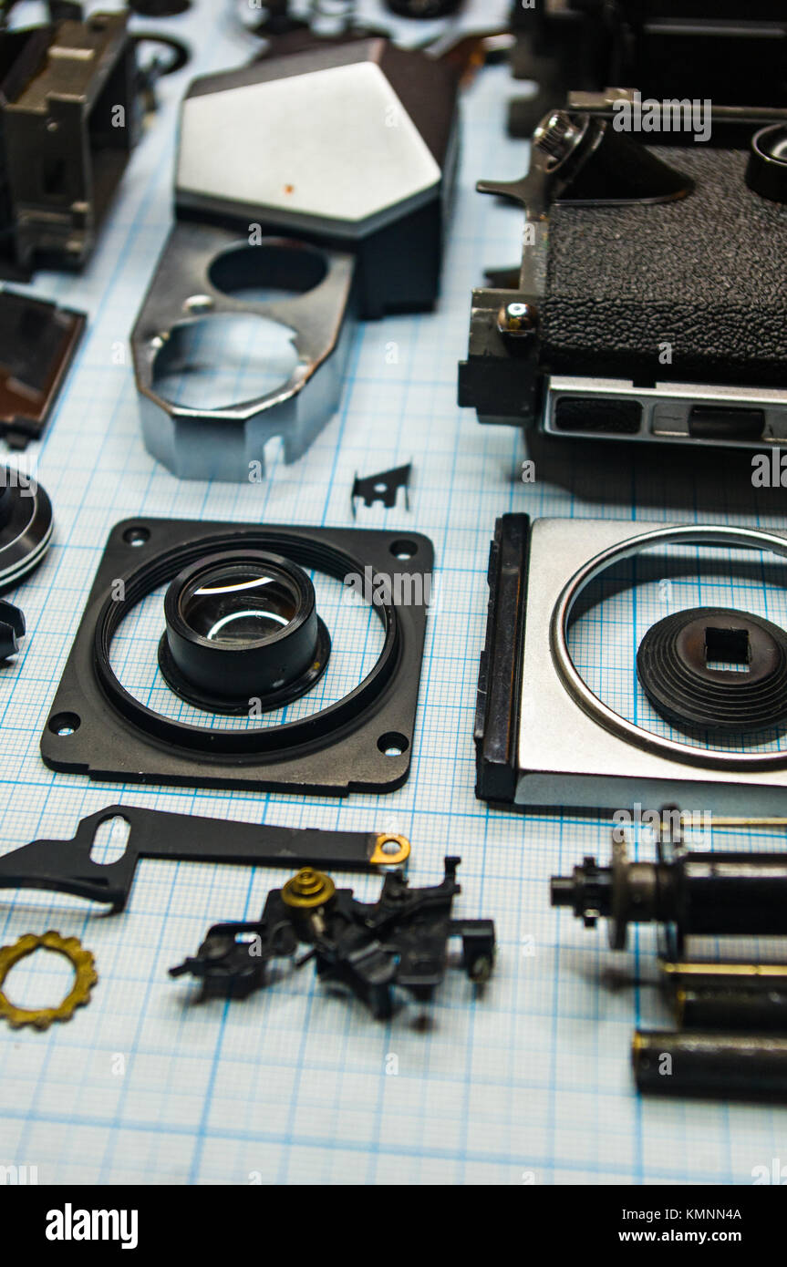 parts are completely disassembled old retro film SLR camera on graph ...