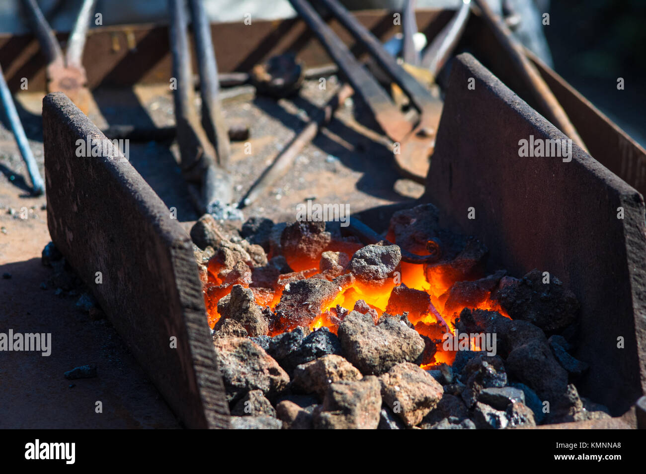 blacksmith furnace with burning coals, tools, and glowing hot metal ...