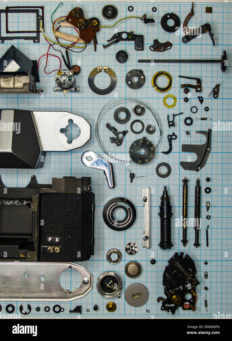 parts are completely disassembled old retro film SLR camera on graph ...