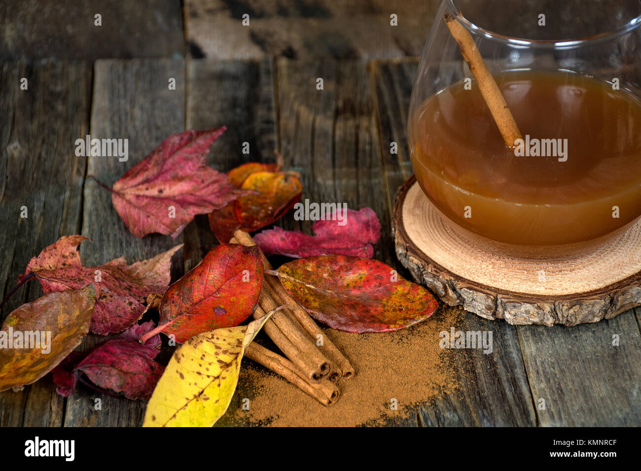 hot apple cider with cinnamon sticks and colorful autumn leaves on ...