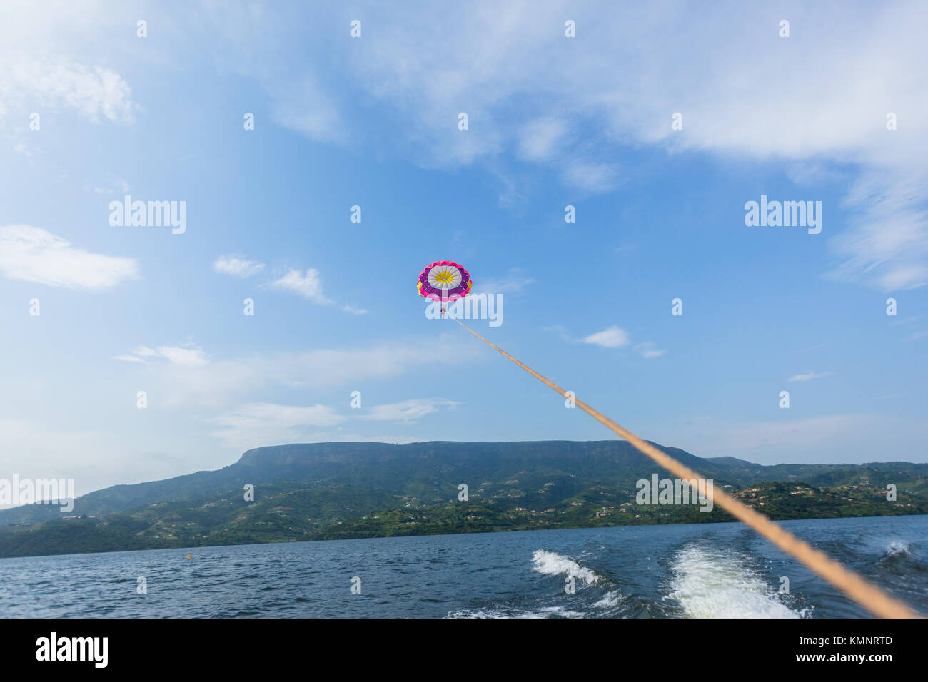 Parachute Gliding sailing woman pulled by rope attached to boat over ...