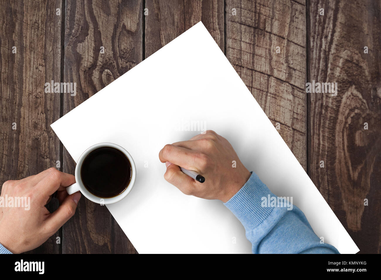 Man writing on paper while drinking coffee Stock Photo - Alamy