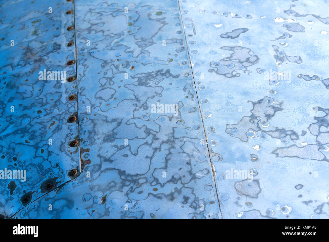 Sanded steel surface with rivets, blue color, prepared for paint, close ...