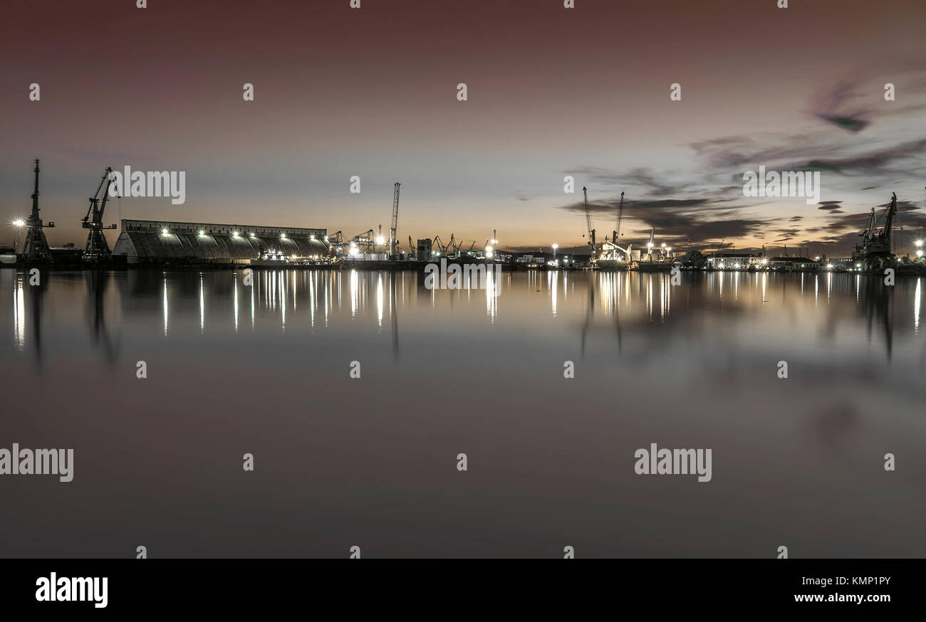 port on sunset with water reflections, loading cargo ship Stock Photo ...
