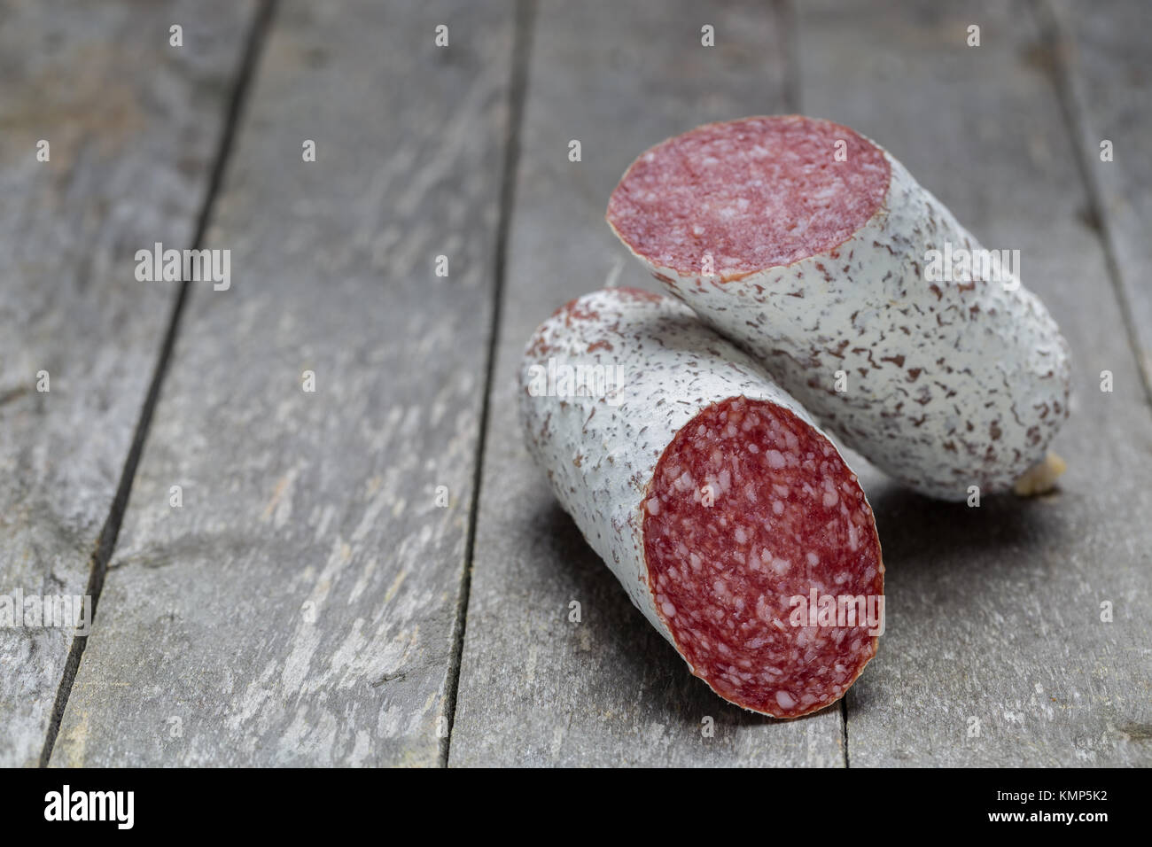 Salami on old gray wood Stock Photo - Alamy