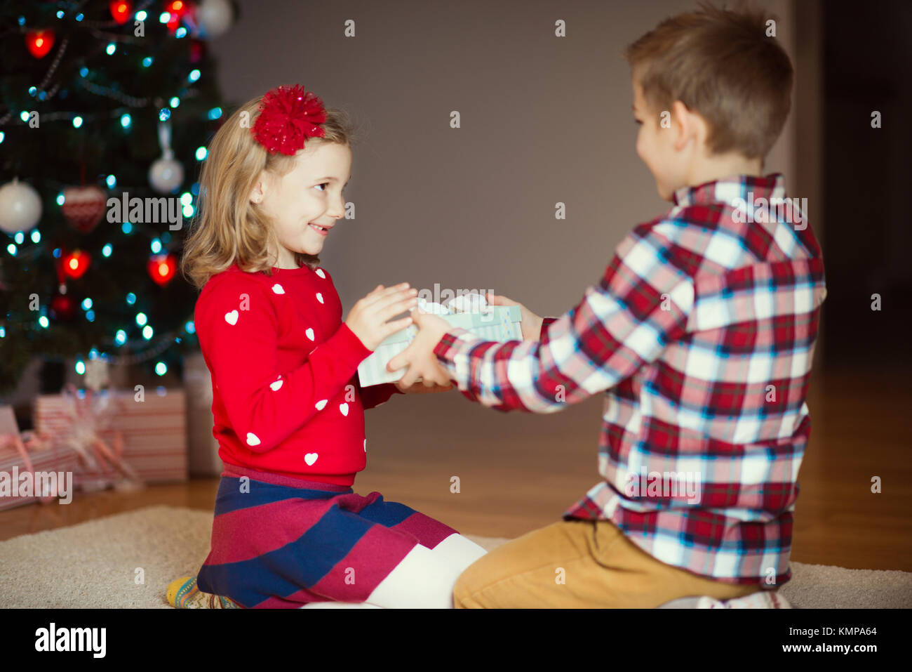 Two happy children in new year eve with presents near New Year Tree at ...