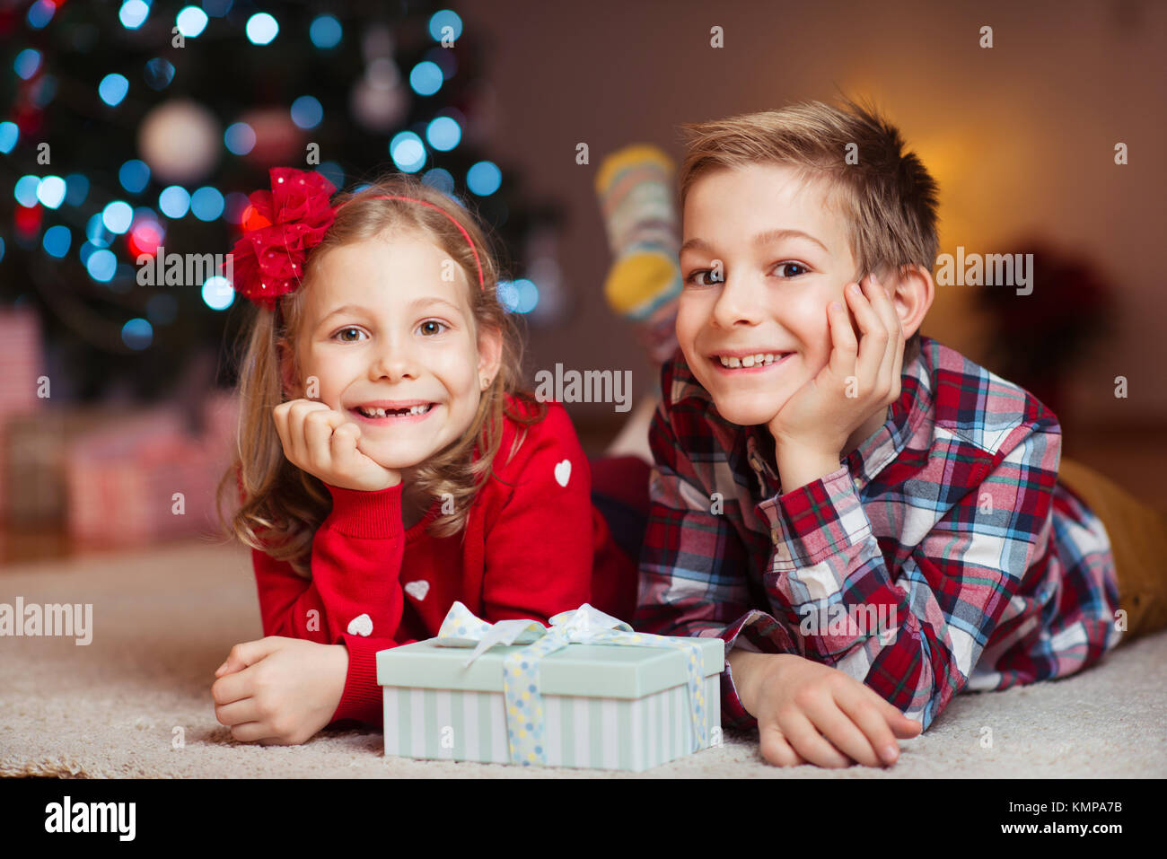 Two happy children in new year eve with presents near New Year Tree at ...