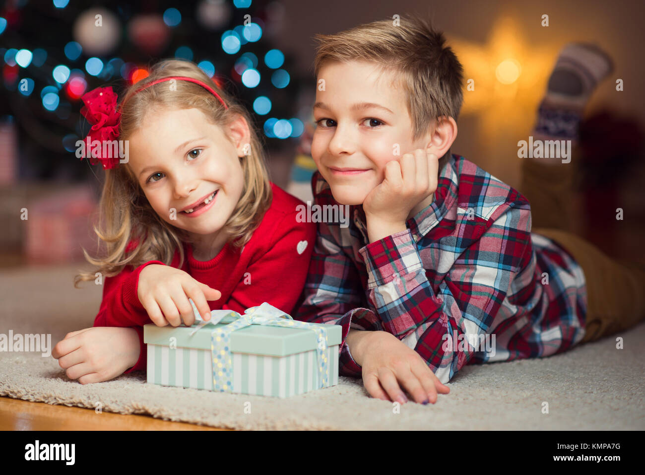 Two happy children in new year eve with presents near New Year Tree at ...