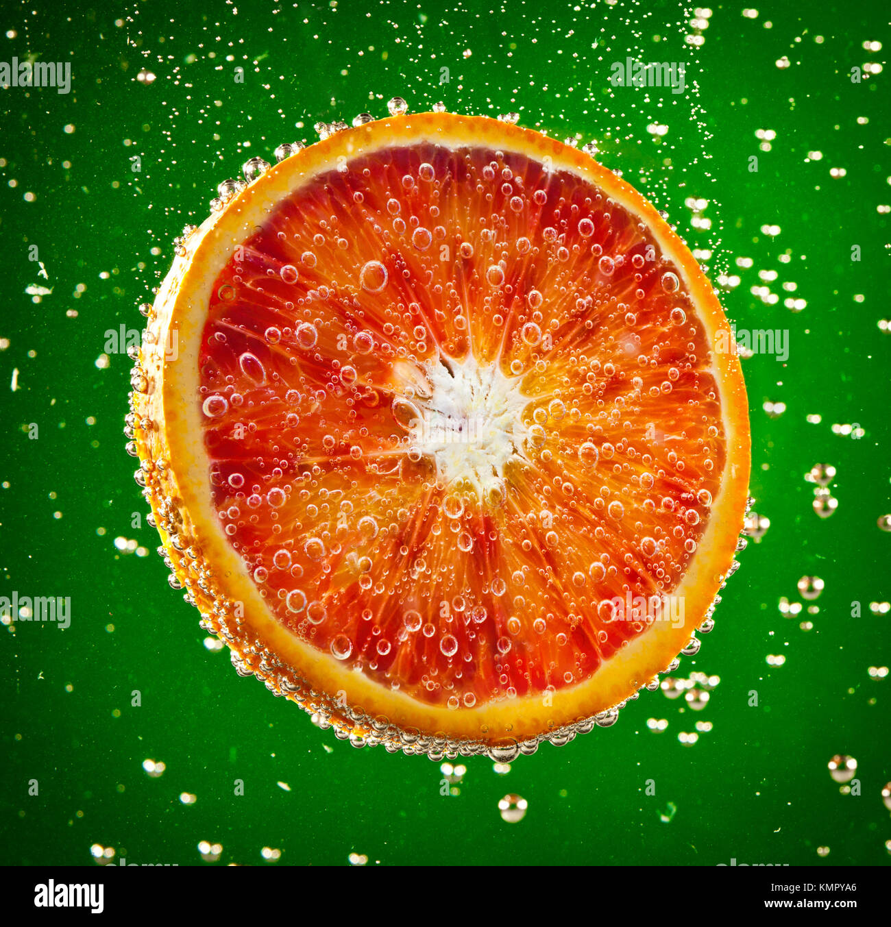 fresh red orange falls in water on a green background Stock Photo - Alamy