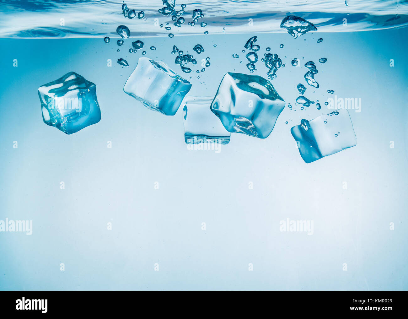 Ice cubes falling into the water sinking to the bottom. Abstract ...