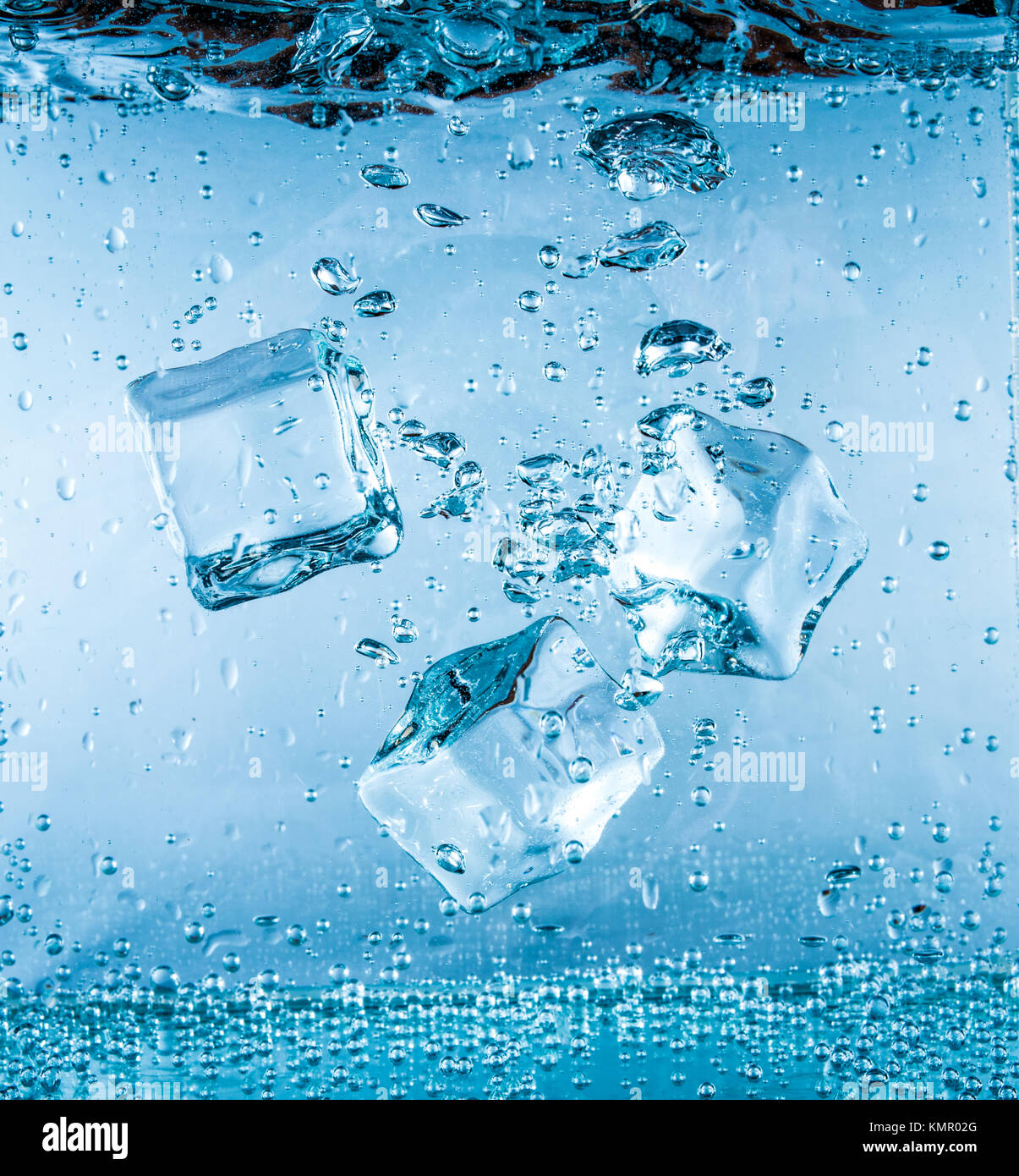 Ice cubes falling into the water sinking to the bottom. Abstract ...