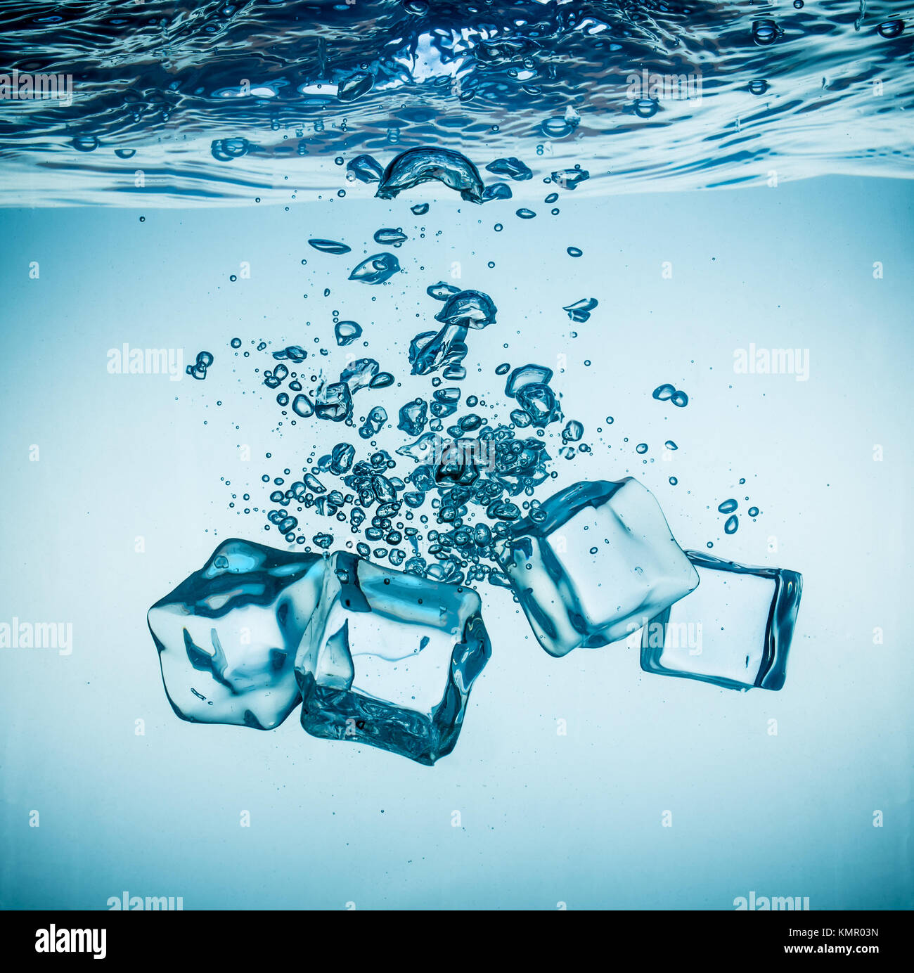 Ice cubes falling into the water sinking to the bottom. Abstract ...