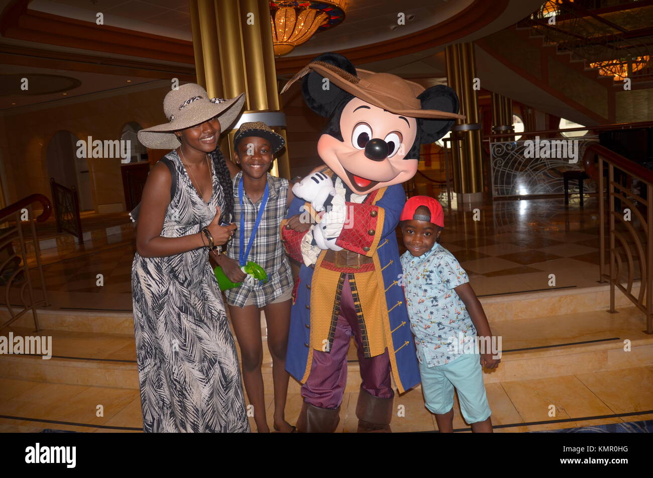 Afro-Caribbean family taking pictures with Mickey Mouse on the Disney ...