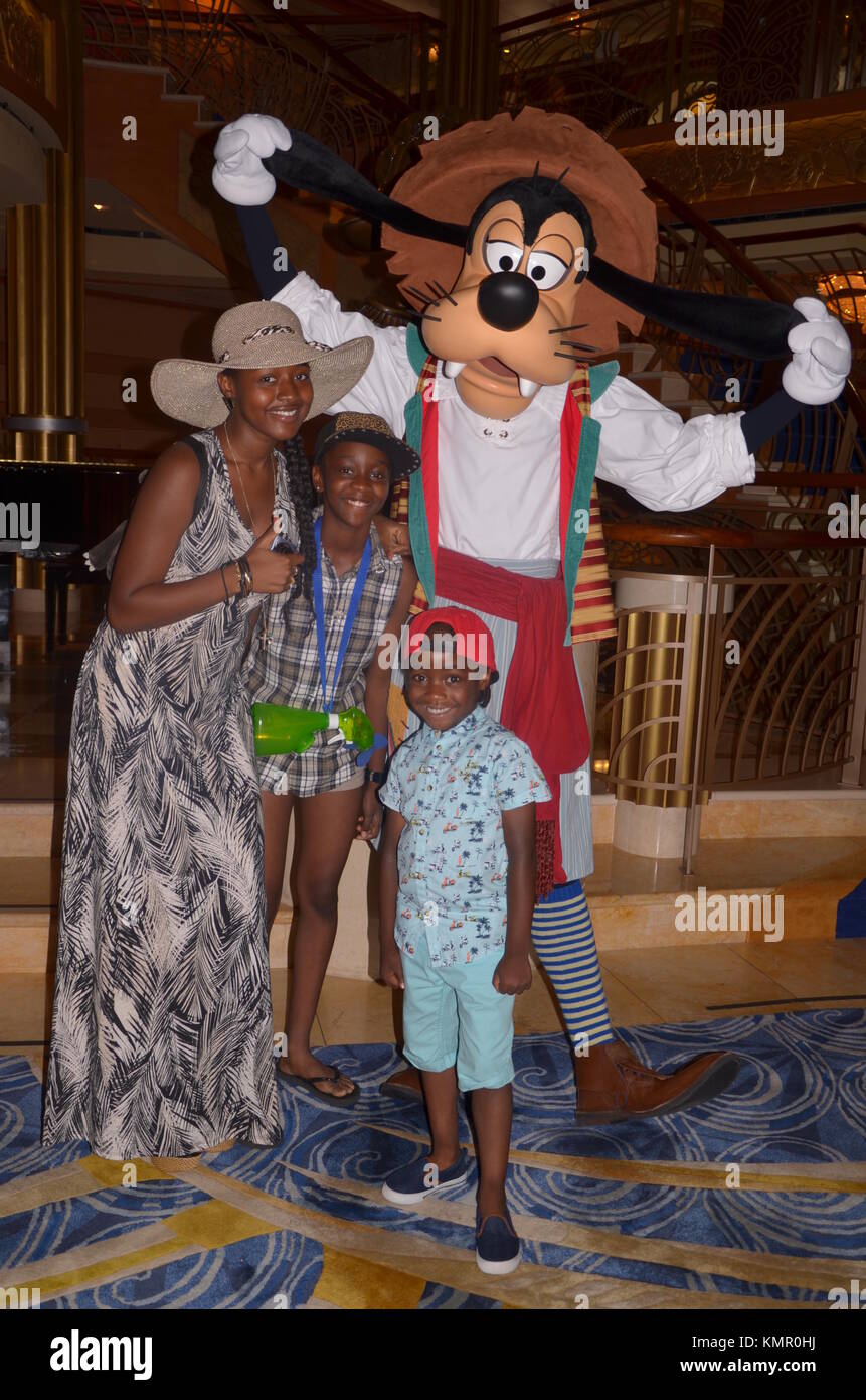 Afro-Caribbean family taking pictures with Disney character Goofy on ...