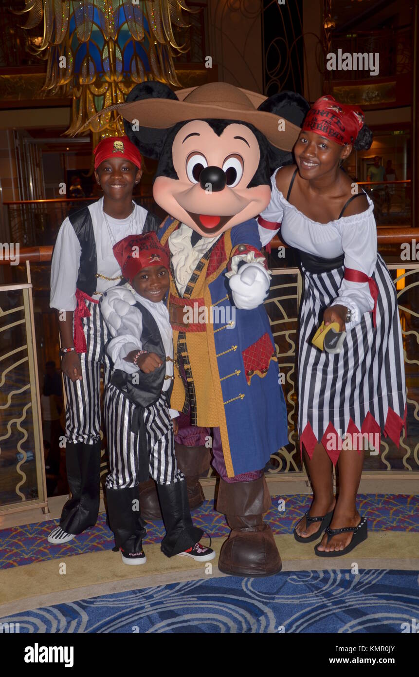 Afro-Caribbean family taking pictures with Mickey Mouse on the Disney ...