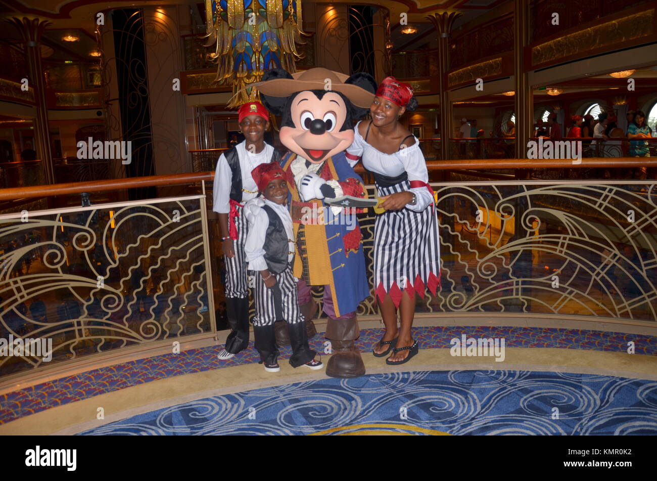 Afro-Caribbean family taking pictures with Mickey Mouse on the Disney ...