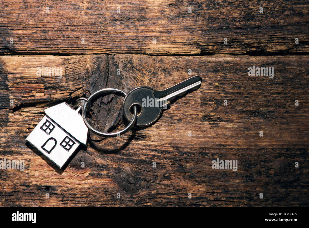House shaped key chain on wooden background Stock Photo - Alamy