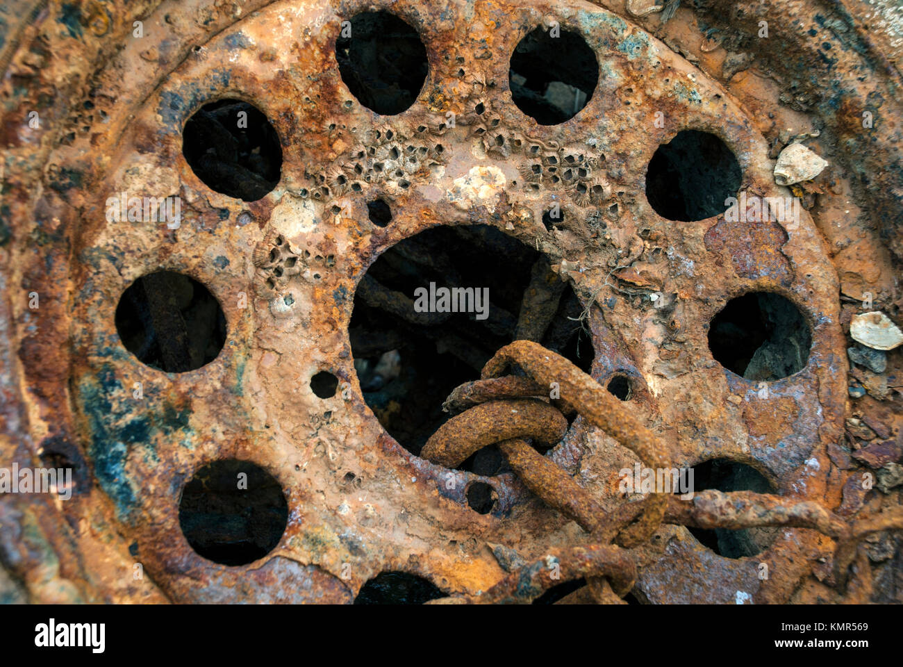 Close up image of a rusty barnacle covered wheel in an old boatyard ...