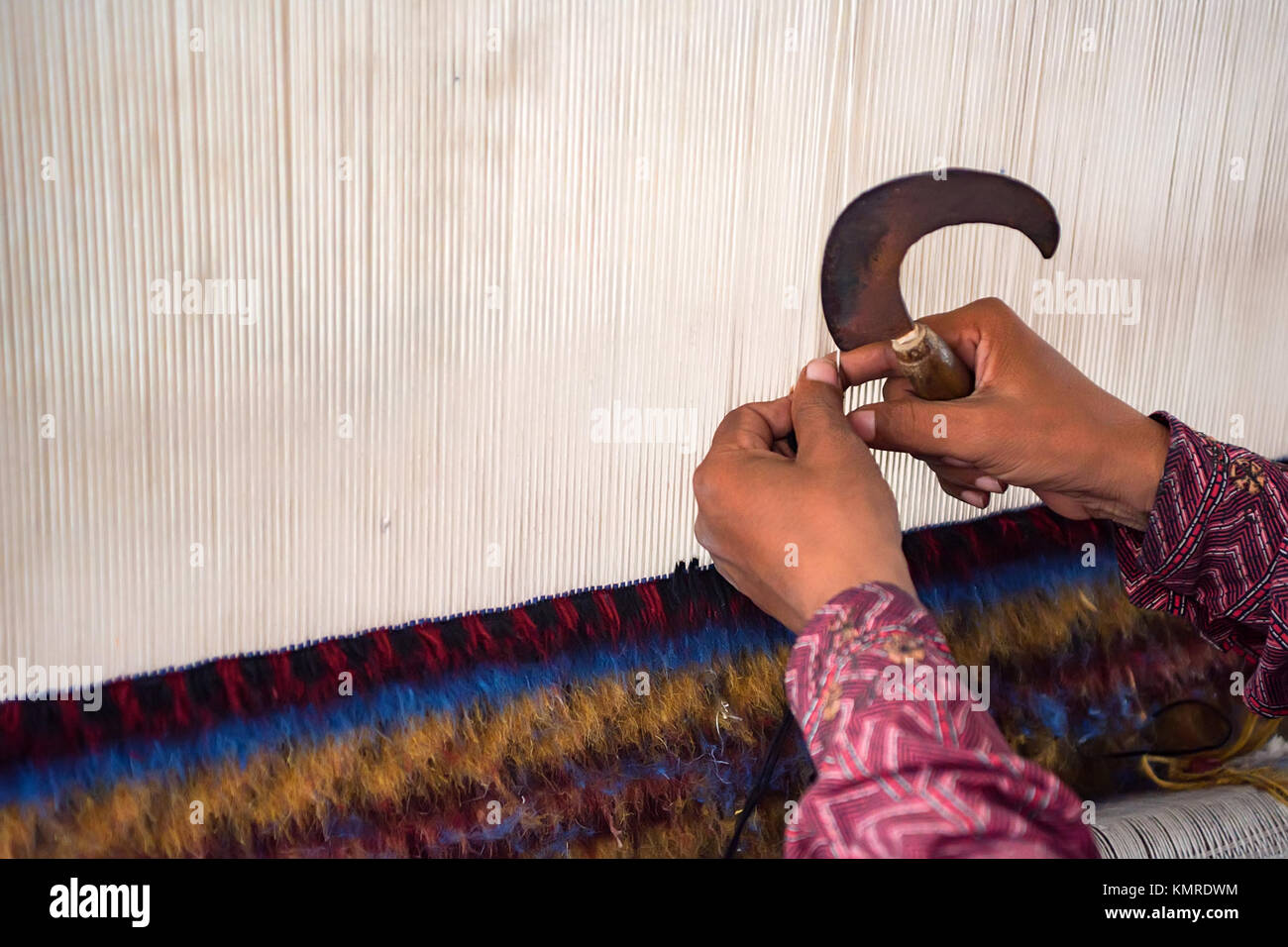 Back view man weaves carpet Stock Photo - Alamy