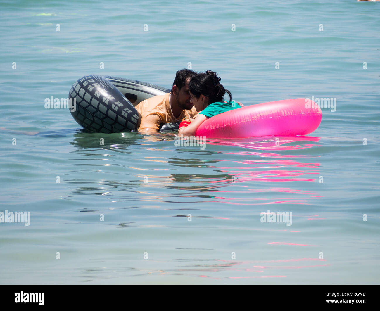 Indian couple in pool floats in the sea Stock Photo - Alamy