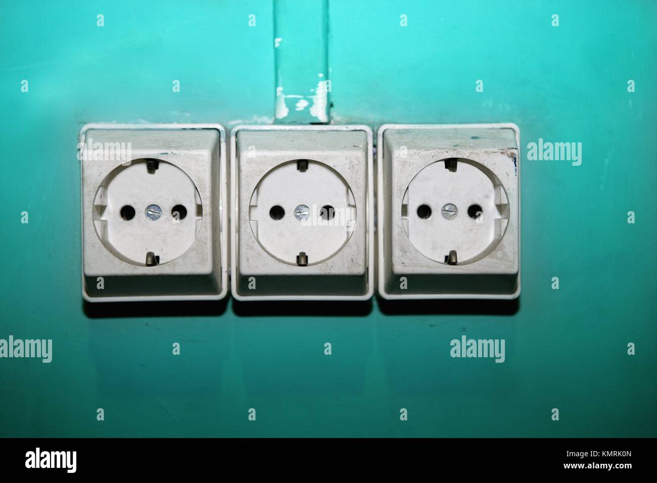 Aged electric plug socket dirty over green wall Stock Photo - Alamy