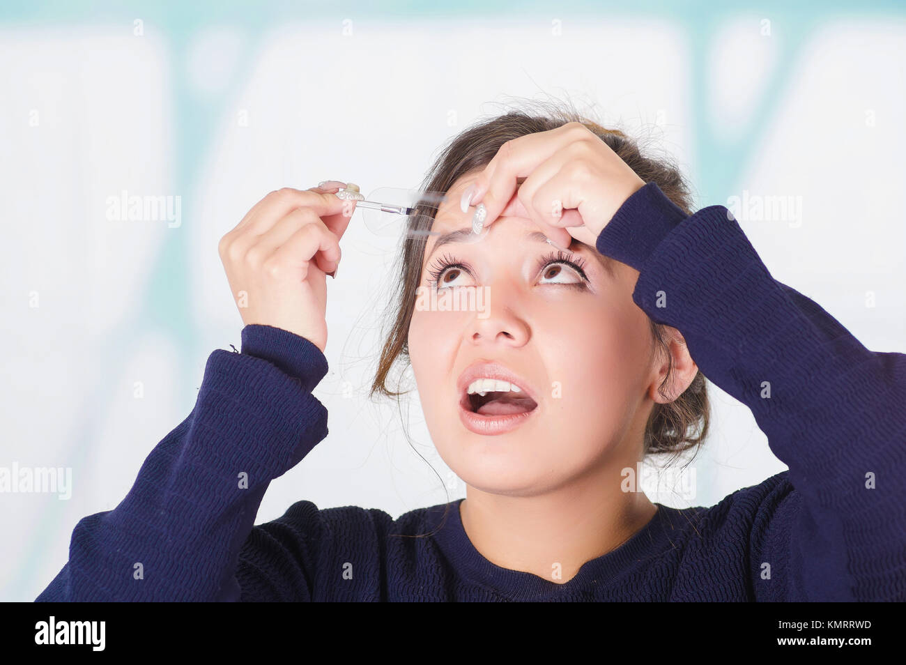 Close up of young beautiful woman doing a mess in her eyebrow in a ...