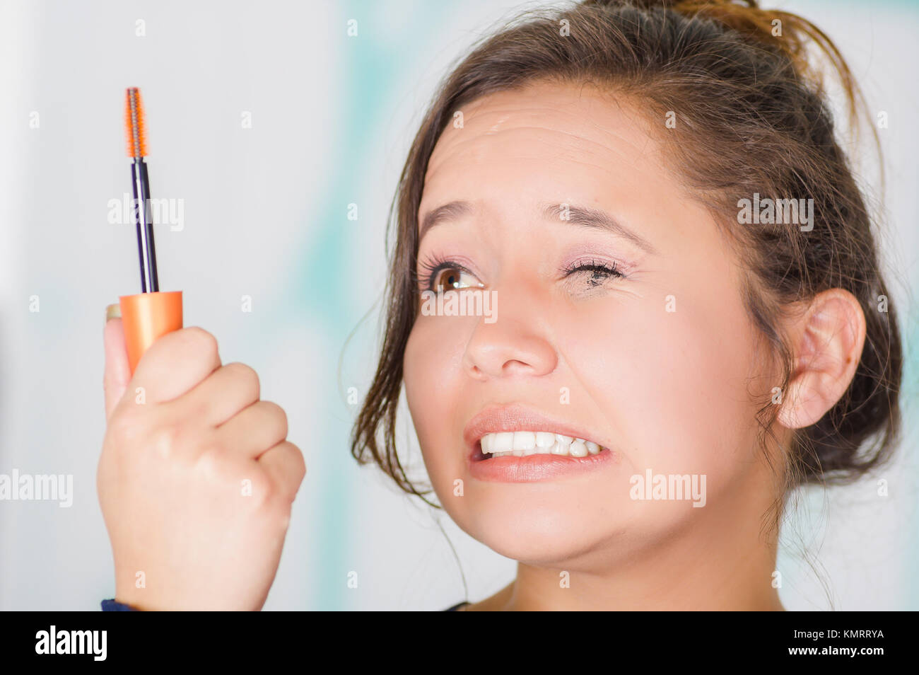 Close up of worried young woman, closing her eye while she is doing a ...