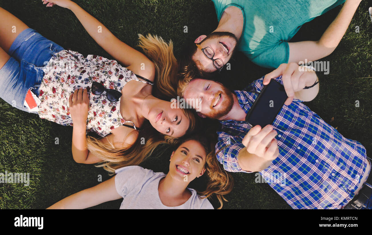 Careless young people having a laugh outdoors lying in grass Stock ...