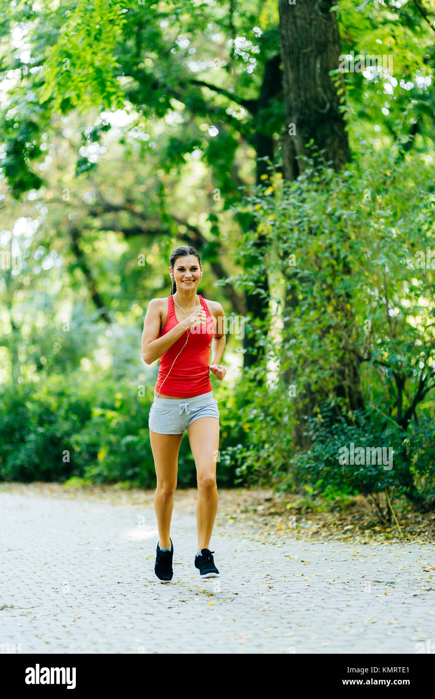 Young beautiful athlete jogging in park Stock Photo - Alamy
