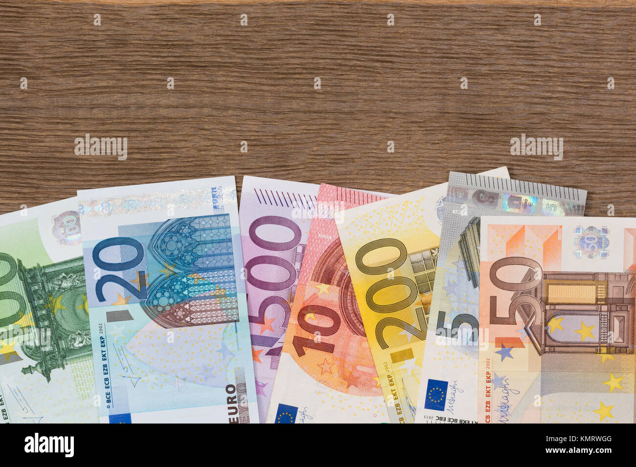 Pile of euro money on wooden desk Stock Photo - Alamy