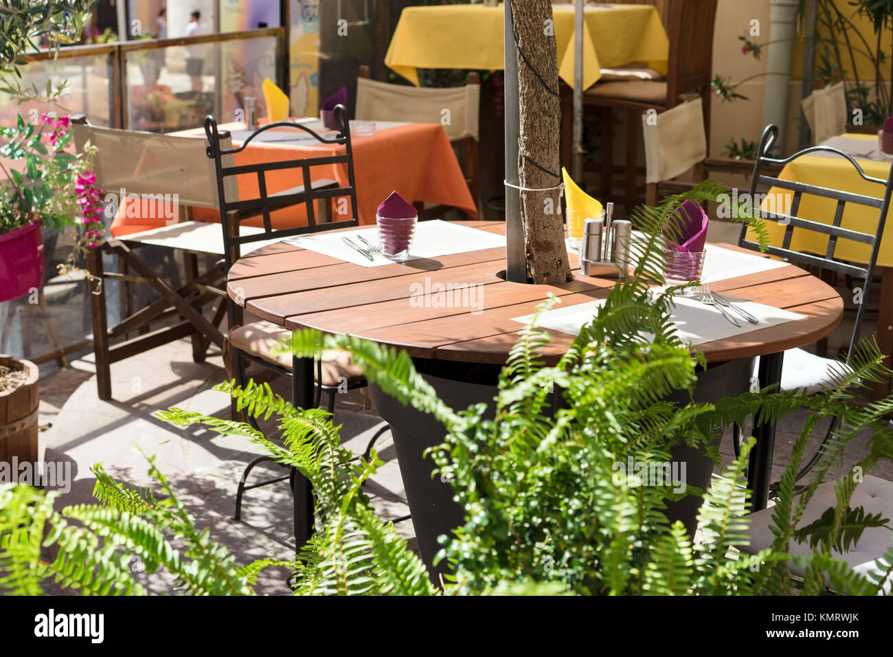 Street cafe terrace with served wooden tables and chairs decorated ...