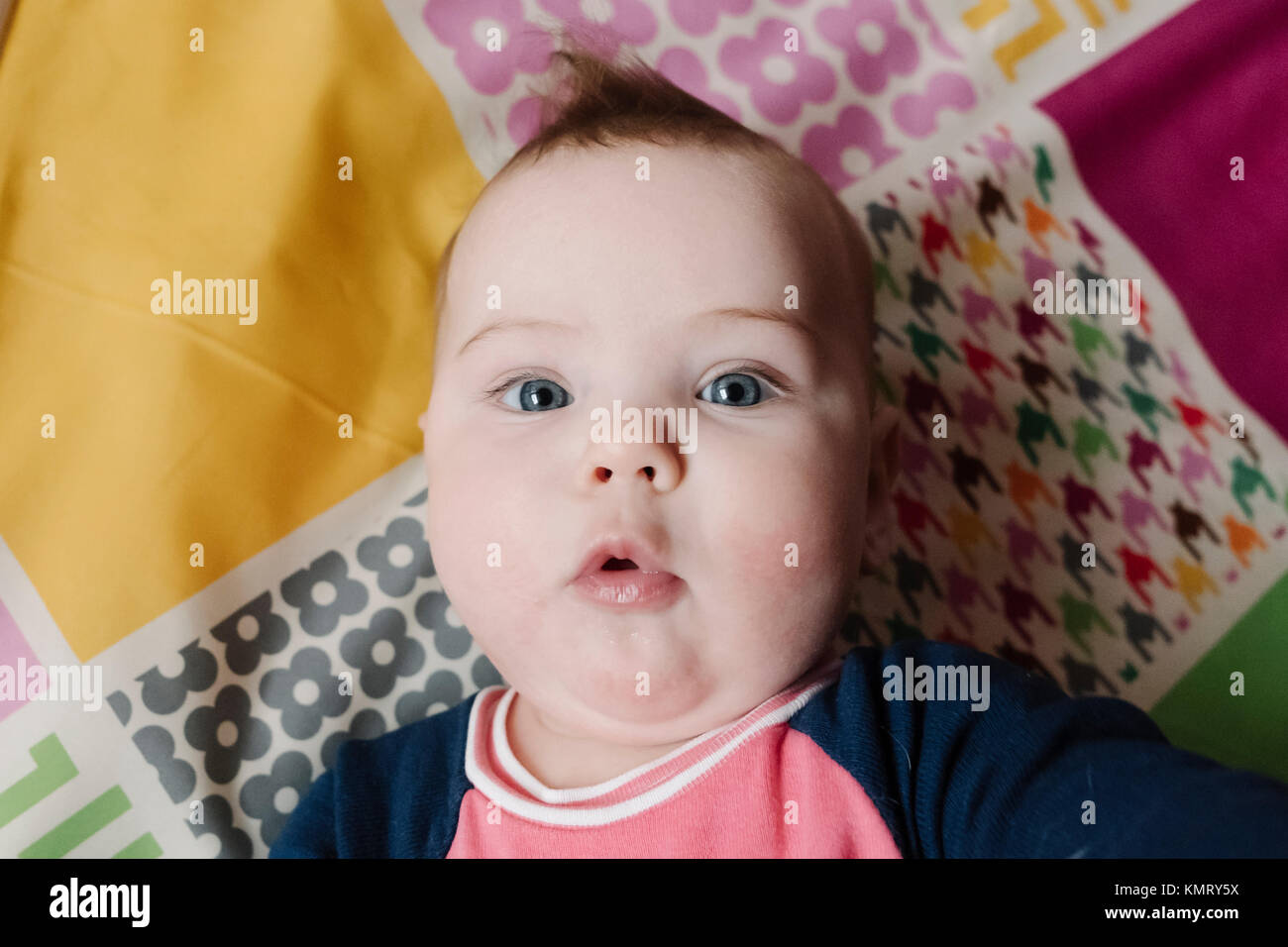 Overhead portrait of baby girl lying on bed Stock Photo - Alamy