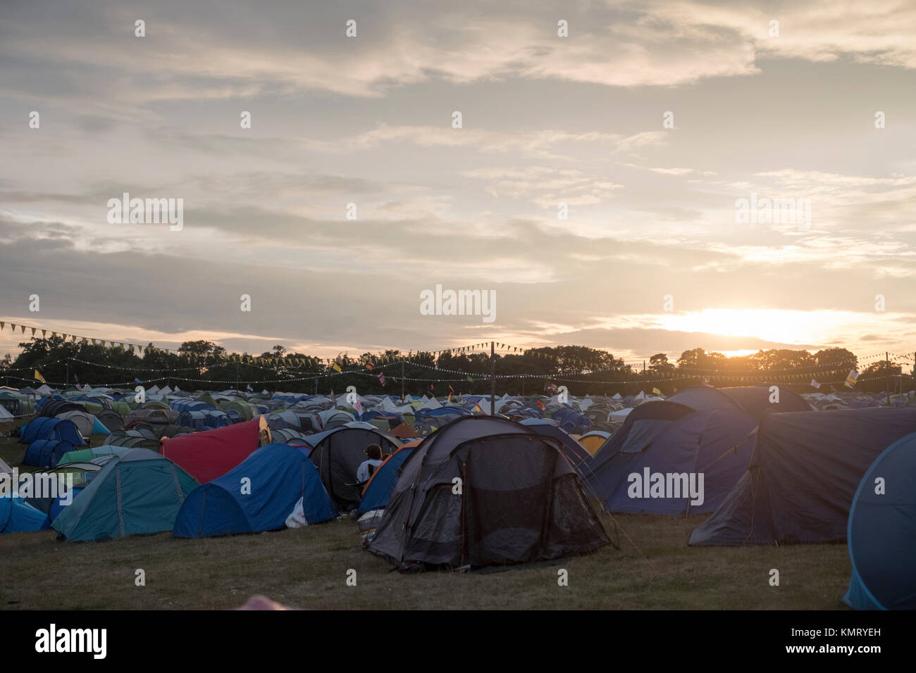 Tents on field against cloudy sky at campsite during sunset Stock Photo ...