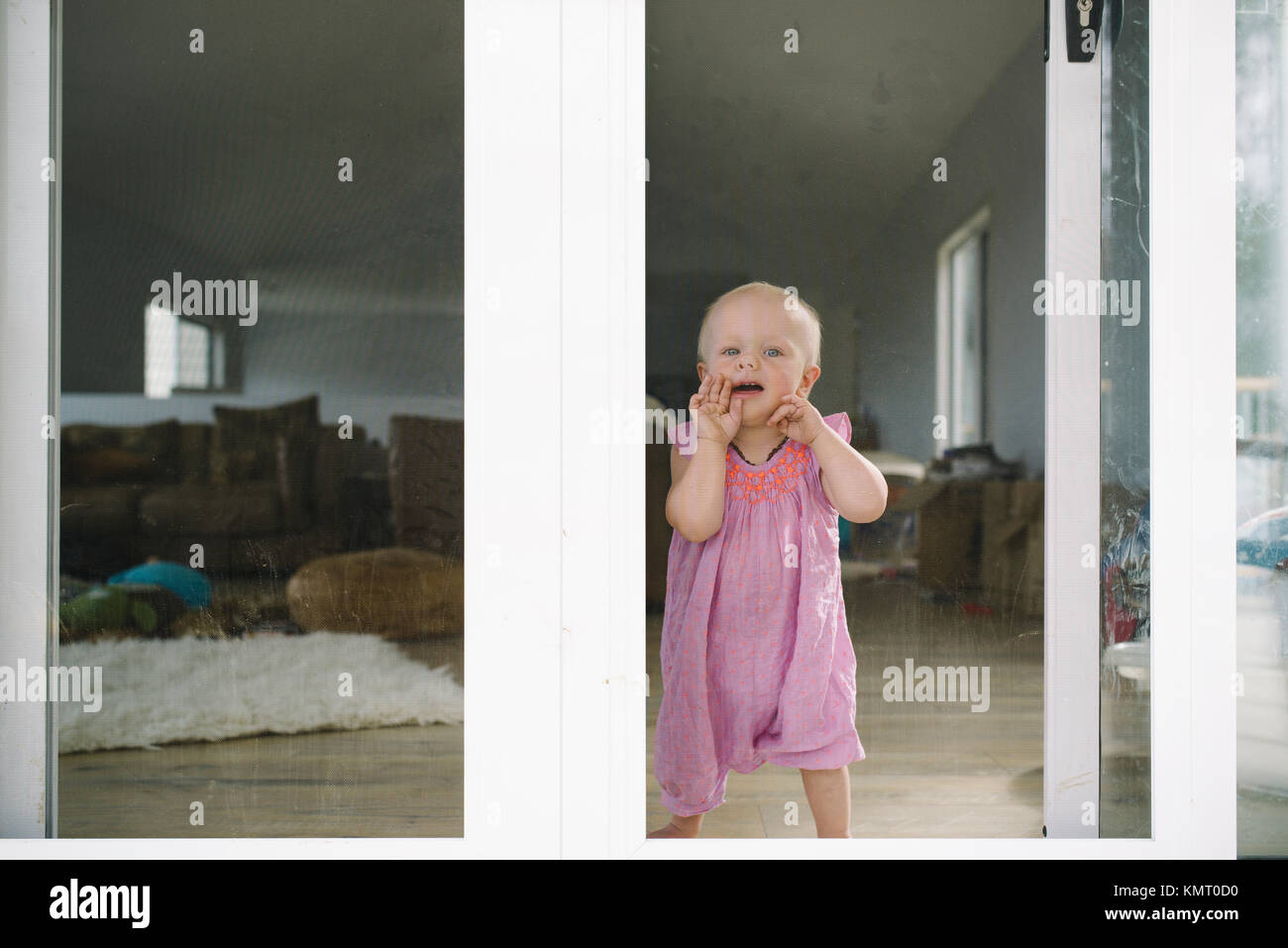 Cute girl shouting seen through window Stock Photo - Alamy