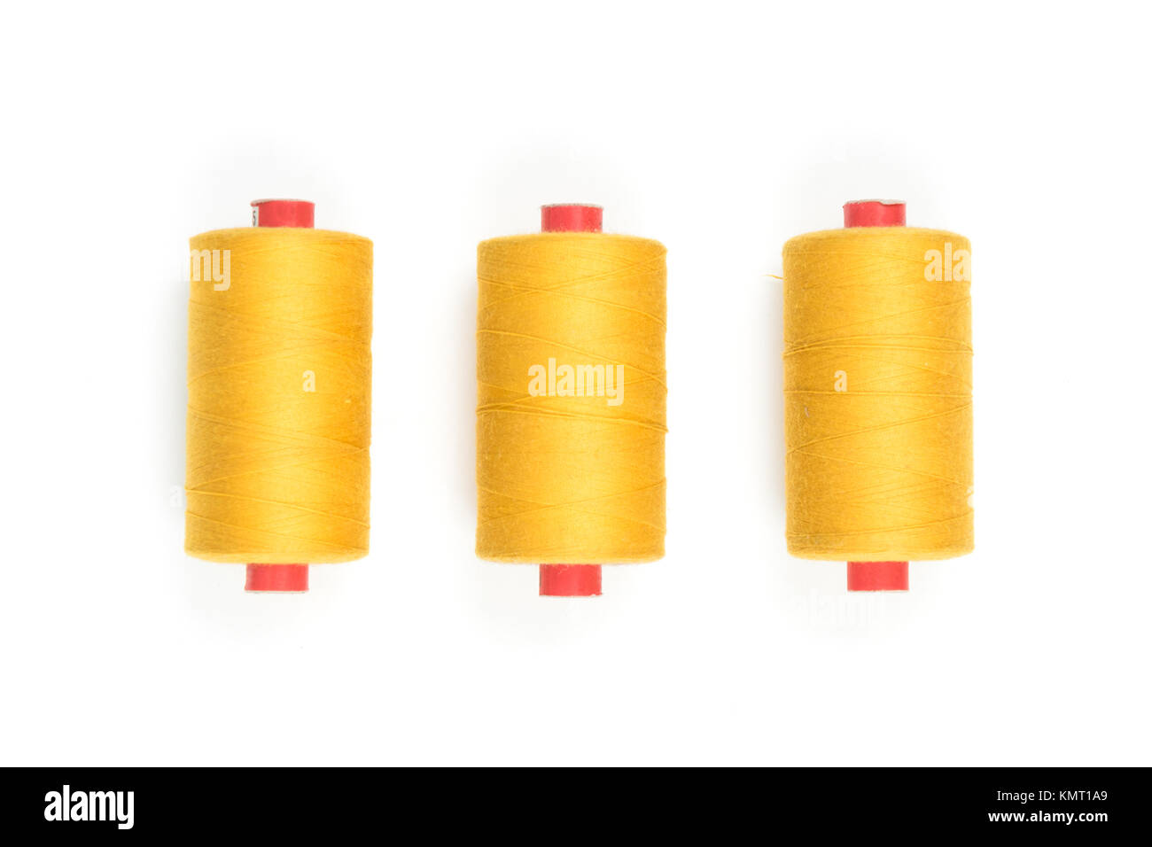 Yellow thread coils on white background, sewing and tailoring supplies ...