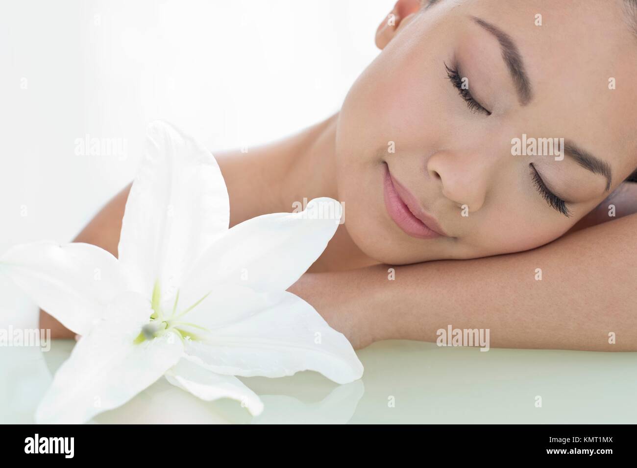 Young woman with eyes closed with lily,portrait Stock Photo - Alamy