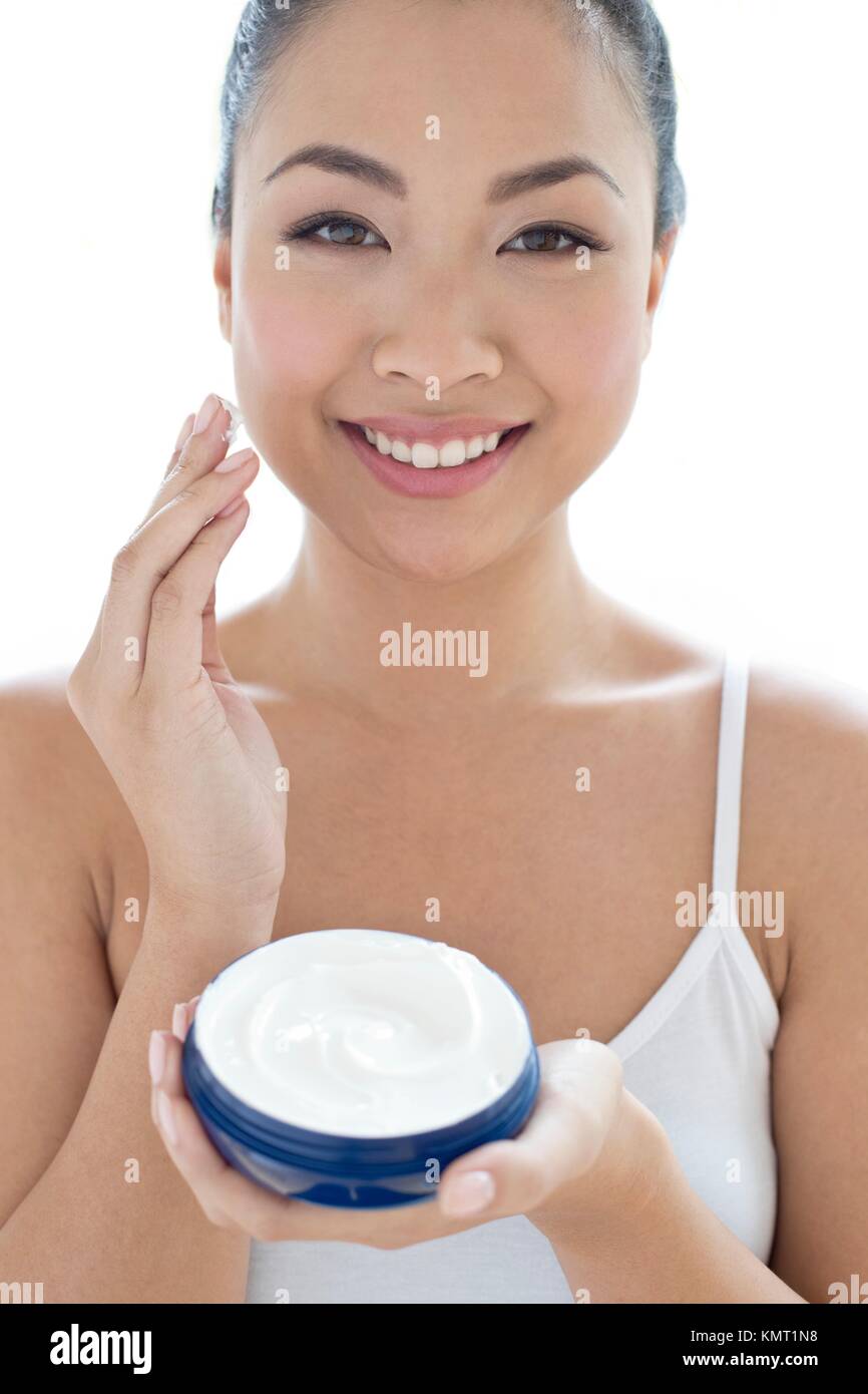 Young woman applying face cream,portrait Stock Photo - Alamy