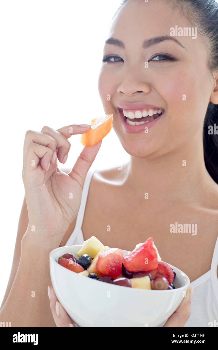 Young woman eating fresh fruit,portrait Stock Photo - Alamy