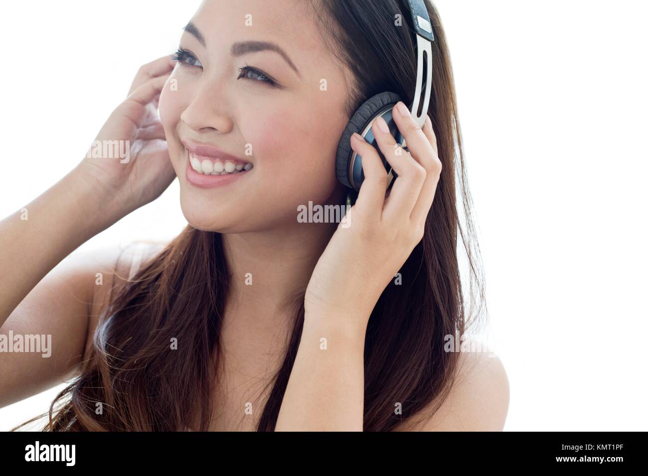 Young woman listening to music wearing headphones Stock Photo - Alamy