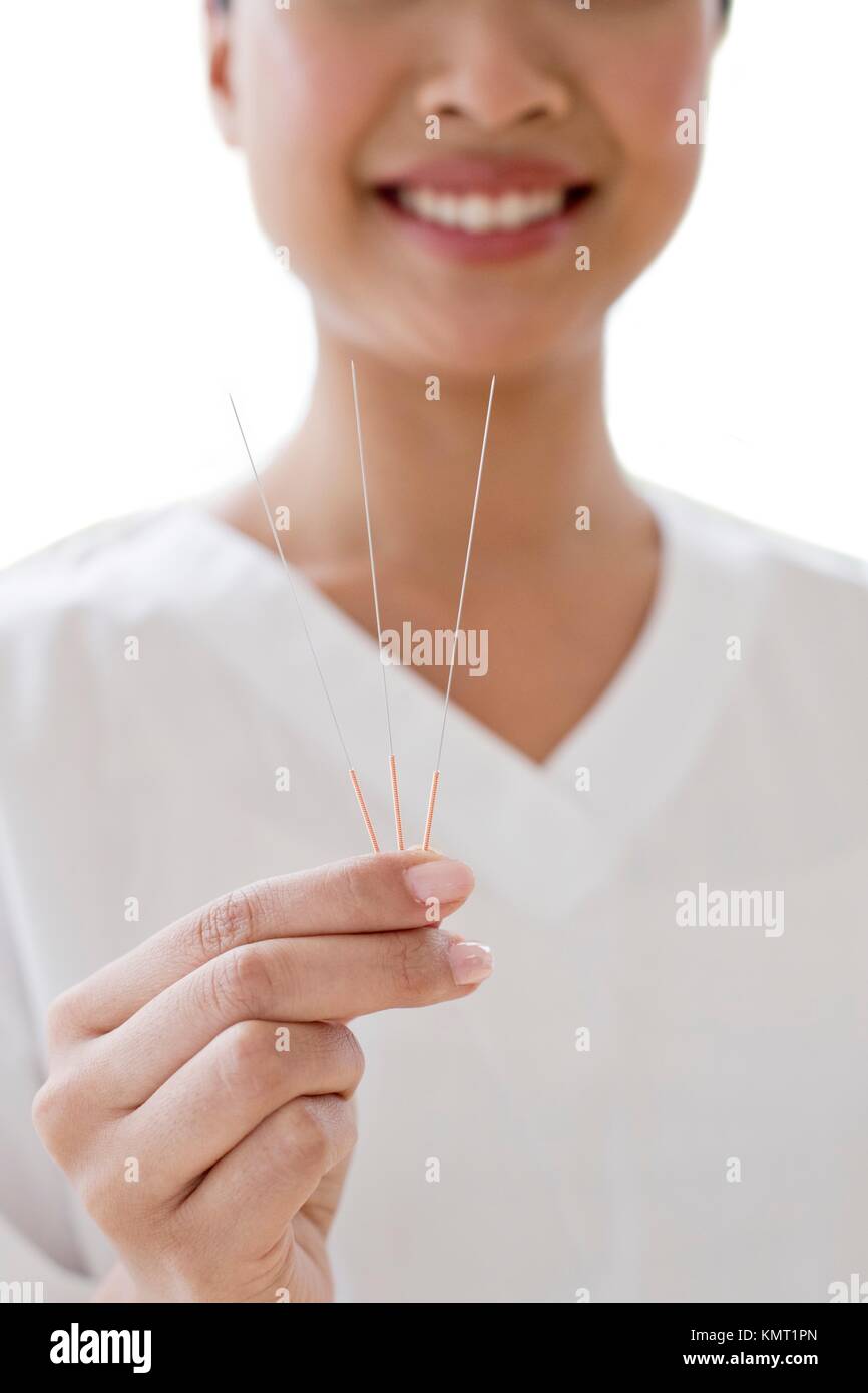 Woman holding acupuncture needles hi-res stock photography and images ...