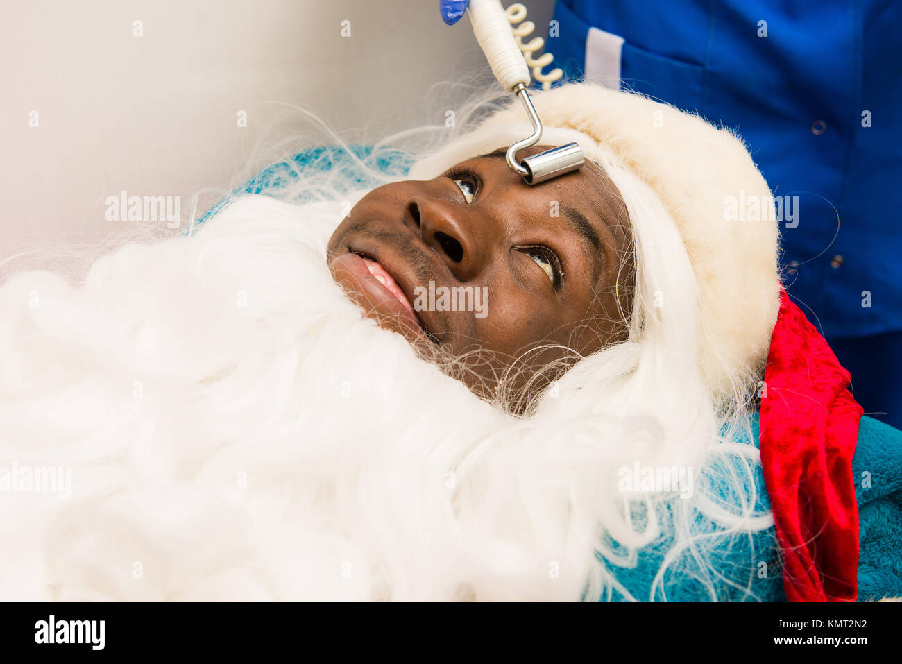 Black Santa Claus doing cosmetic procedures in spa clinic. Cosmetic ...