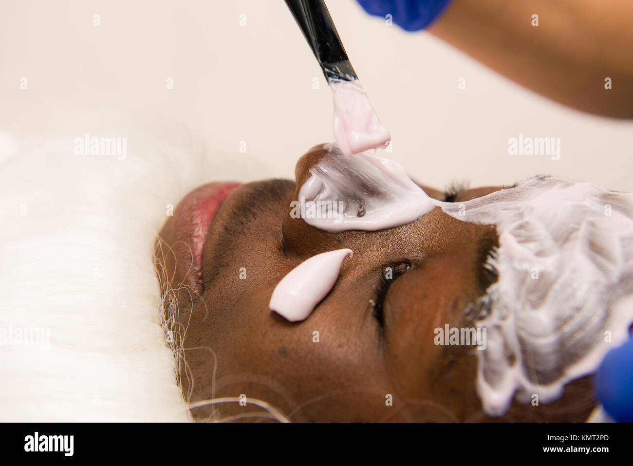 Spa facial mask application. Side view. Black santa claus in beauty spa ...