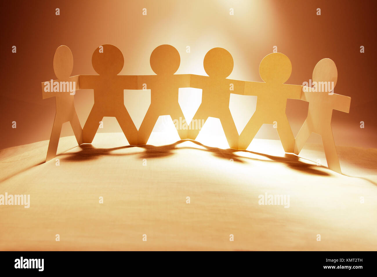 Team of paper chain people in a row holding hands Stock Photo - Alamy