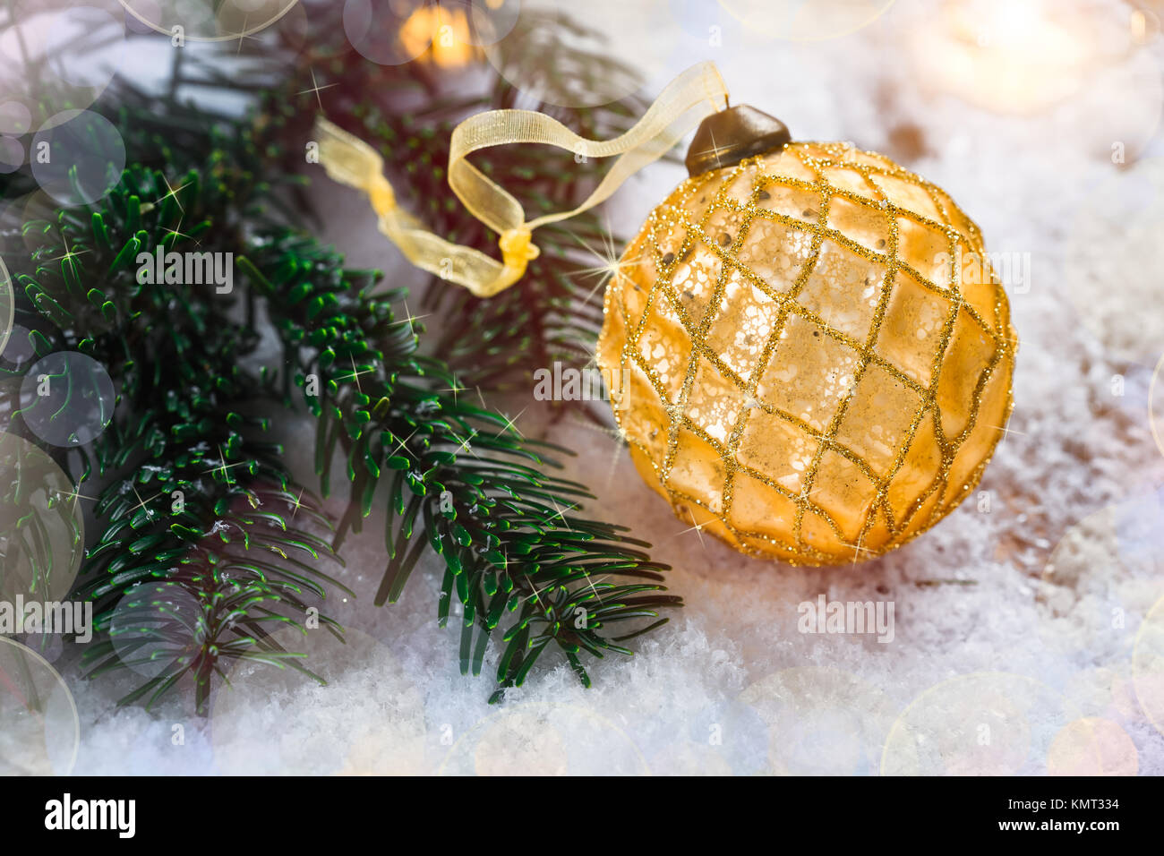 Golden Christmas ball on snow near branches of fir tree. Festive ...